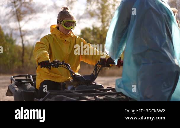 Slow motion. ATV rider in yellow jacket accepts assistance as guide ...