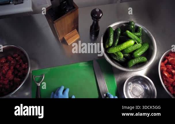 A chef wearing blue gloves takes out kitchen knife and cuts the ...