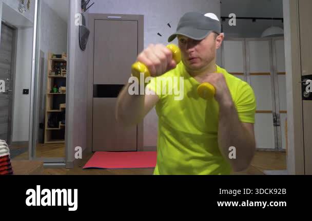 Boxing with dumbbells in hands. Boxing training at home, men's workout ...