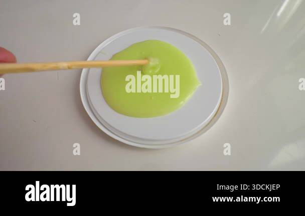 Calibration of green paint at home, mixing paint with a wooden stick. Slow motion Stock Video ...