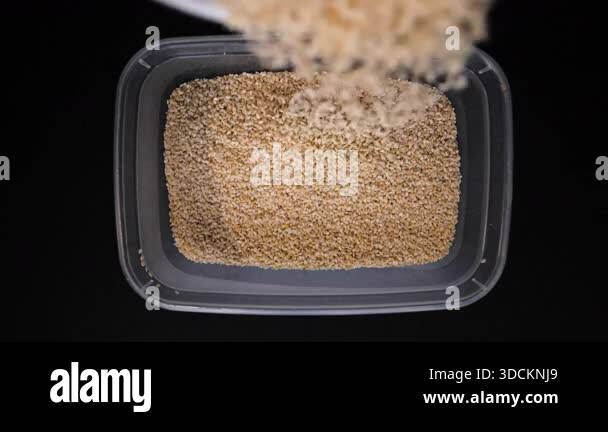 Sesame seeds fall in slow motion. Pour sesame seeds into a plastic ...