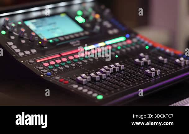 Closeup audio mixing console glowing faders, engineer adjusting levels ...