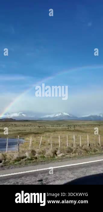 Vibrant Rainbow Over Snow-Capped Mountains and Open Field. High quality ...