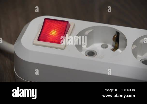 Power adapter is inserted into electric portable socket with red power ...