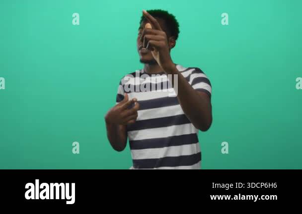 Man in navy and white striped shirt pointing finger outward in green ...