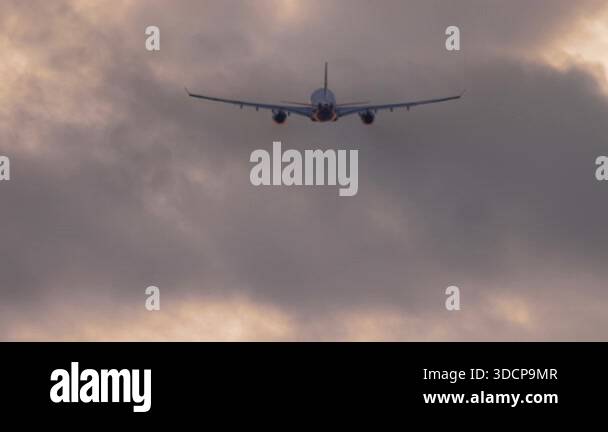 Cinematic footage of an airliner gaining altitude in a cloudy sunset ...