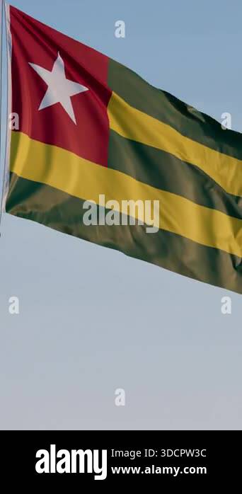 Togo, Lome: Cinematic Vertical Waving National Flag Against Blue Sky ...