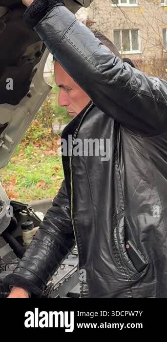 Checking car engine oil, african american man holding dipstick and ...