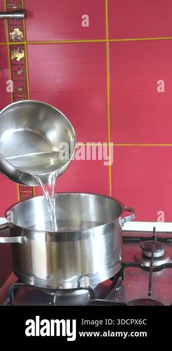 Preparing sugar syrup for soaking cake crust. Professional chef pouring ...