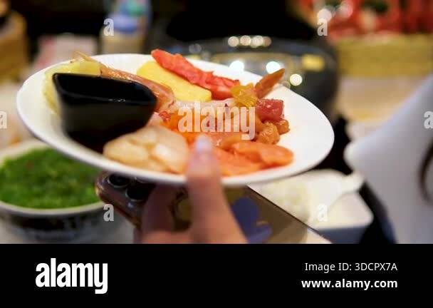 A rectangular plate of assorted sushi, including nigiri, sashimi, and ...