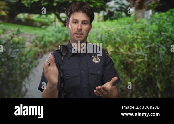 Man police officer clapping hands and speaking into radio on street ...