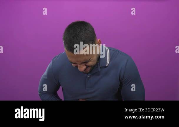 Young hispanic deeply muscular man hunched over and grimaces with ...