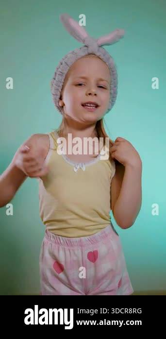 Vertical. Young child with bunny ears headband singing and dancing ...