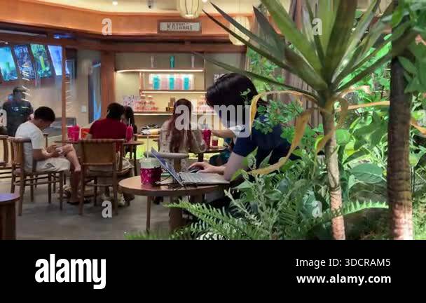KATINAT Nguyen Van Thoai sit at tables with vibrant pink cups on phones ...