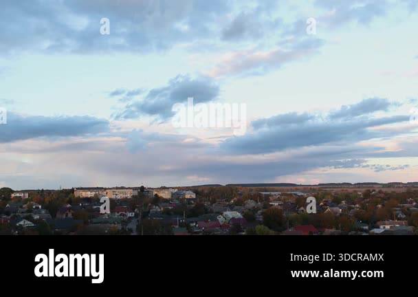 Timelapse of dramatic blue-gray clouds moving fast over autumn suburban ...