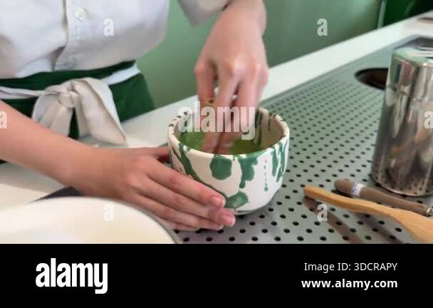 women baristas in stylish cafe preparing matcha tea using ceramic cups ...