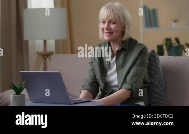 Caucasian old senior woman talking happy video call with laptop at home ...