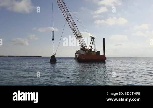 a dredge with crane dredging the sea bottom near the shore Stock Video ...