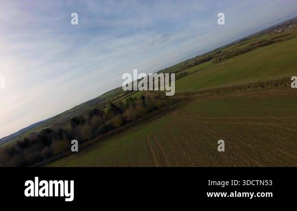FPV drone aerial view over rural landscape and livestock, sunny England ...