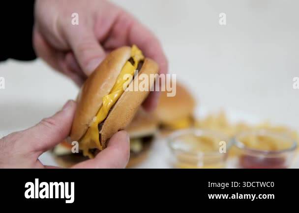 hands breaking apart a burger men hands breaking chicken burger bun on ...