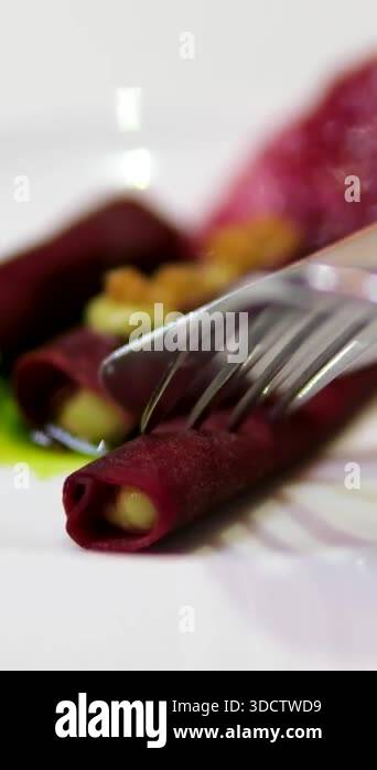 Close-up of a fine dining beet dish topped with vibrant pink molecular ...