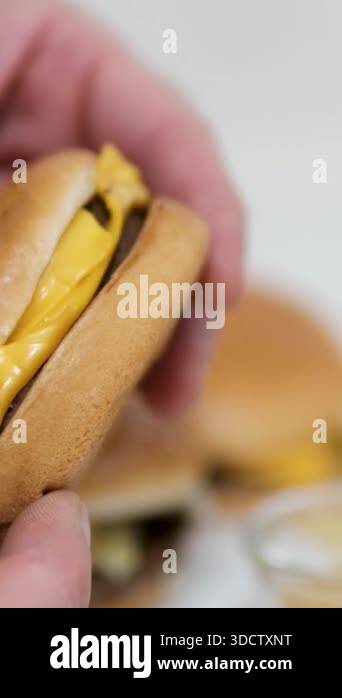 hands breaking apart a burger men hands breaking chicken burger bun on ...