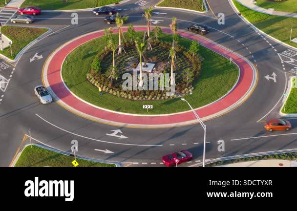 Roundabout intersection on American road with driving cars. High angle ...