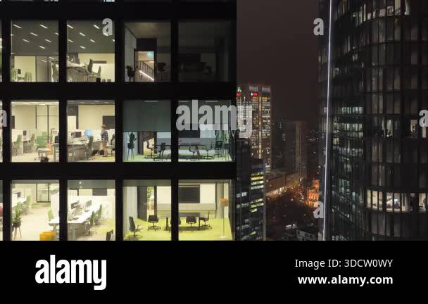 Employees work late in a modern skyscraper office building, aerial view ...