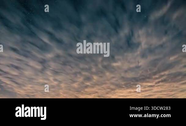 Evening time lapse of fast-moving clouds drifting across a starry night ...