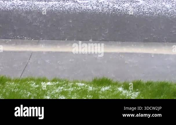 A detailed image showing a close-up view of hailstones densely covering ...