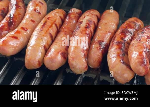 Slow motion- Close-up of grilled sausages with prominent grill marks ...