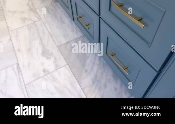 Side view of blue vanity cabinets with gold-toned hardware. Subtle ...