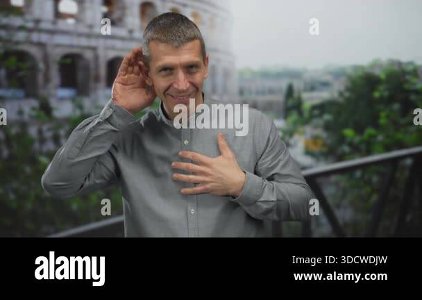 Man listening intently outside the iconic roman coliseum in rome ...