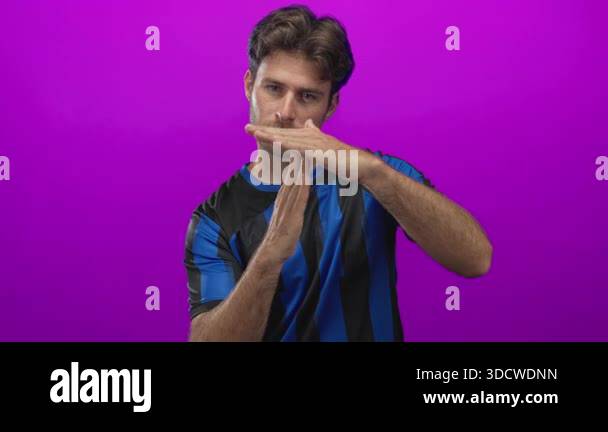 Man performing time out hand gesture in studio with purple backdrop and ...