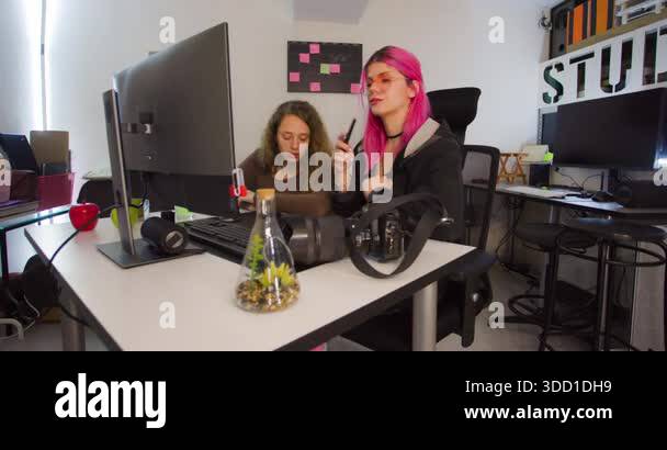 Two female colleagues in a photography studio review photo shoot ideas ...