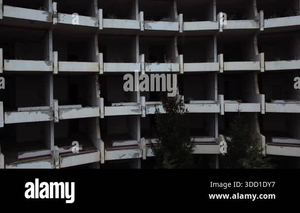 Abandoned hotel balconies overgrown with weeds, symbolizing decay and ...
