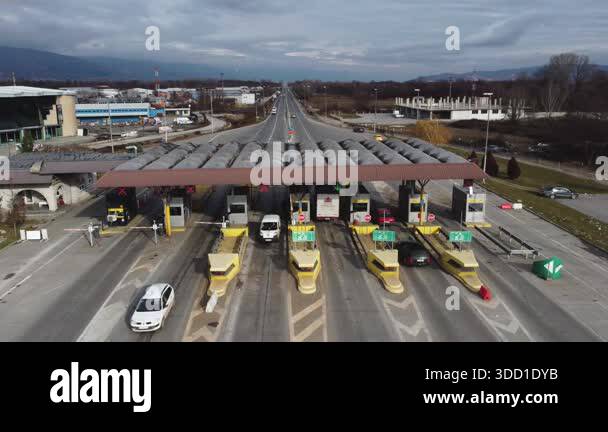 Cars pass through a toll booth on a highway. The video shows the toll ...