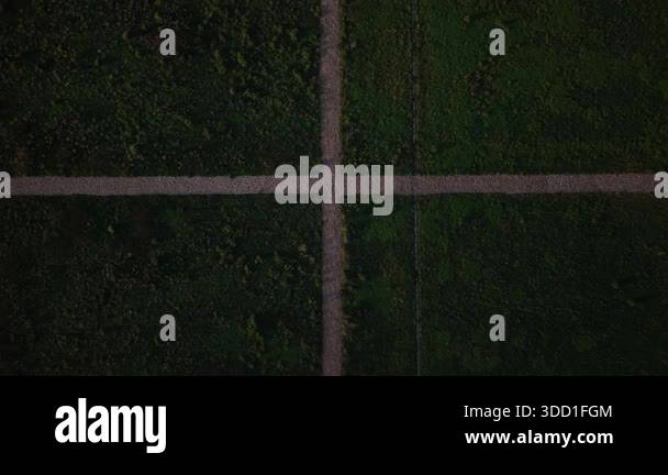 An aerial view shows farm fields segmented by dirt roads during dusk ...