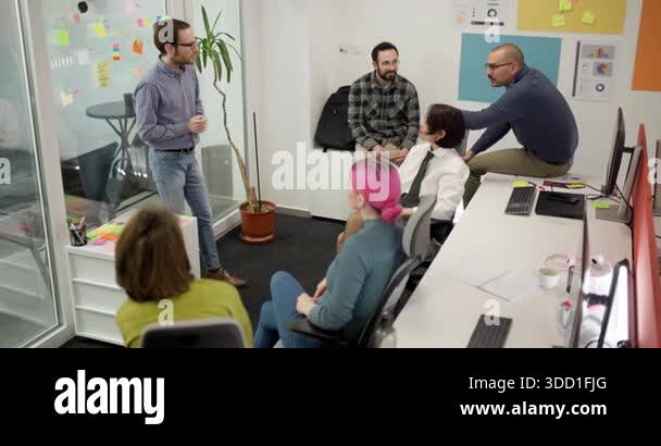 Employees gather in an office to share ideas and discuss business ...