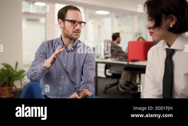 Two team members engage in a discussion about project ideas in a modern ...