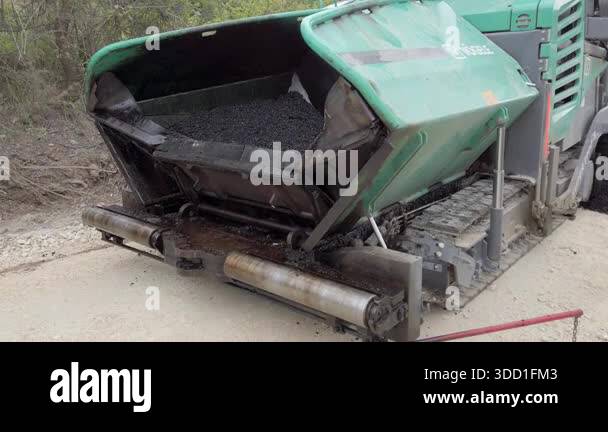 Road construction. Asphalt pavement machine making new layer of asphalt ...