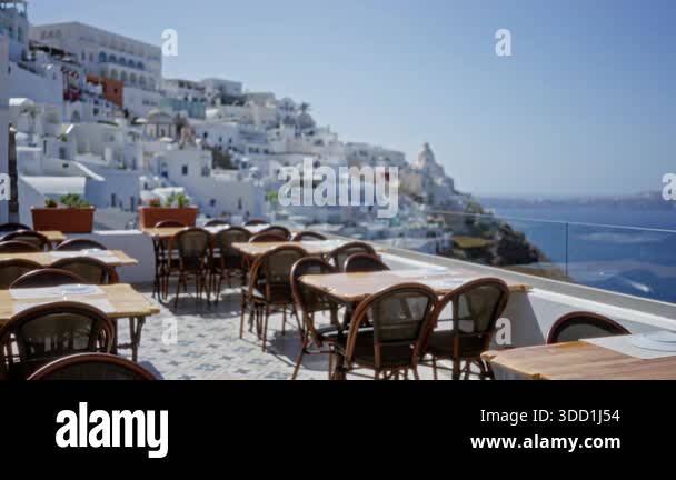 Santorini terrace cafe with defocused bokeh view of white cliffside ...