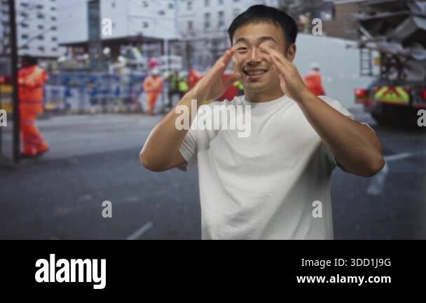 Young chinese man cups head in front of building under construction ...