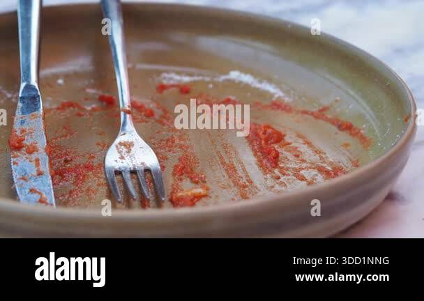 Plate is clean with leftover food remnants shown. Fork and knife rest ...