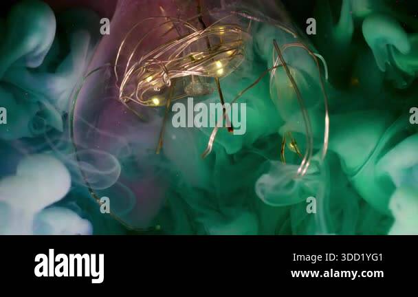 Ink cloud. Defocused garland illumination. Blue green purple smoke ...