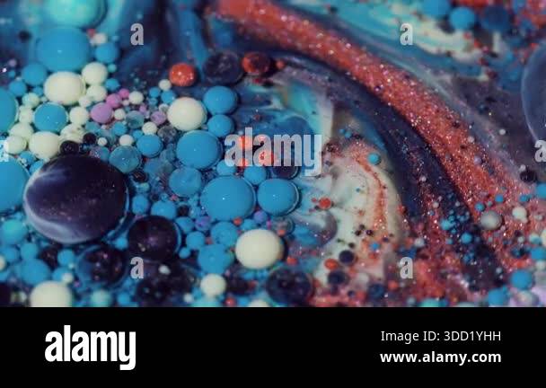 Sparkling paint. Oil fluid. Defocused blue orange purple color ink ...