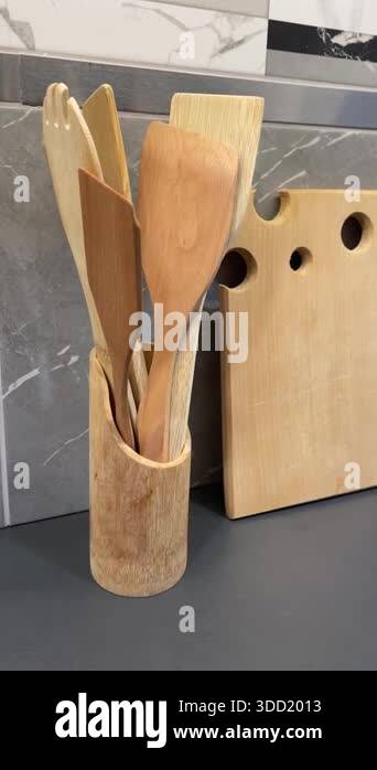 on the kitchen table there are wooden spoons and spatulas, a board for ...