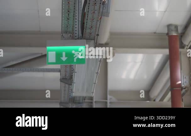 A green exit sign shows the way to an emergency exit indoors Stock ...