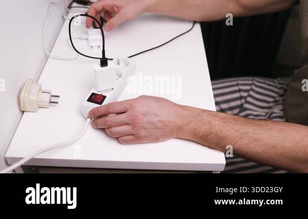 Close-up of male hand plugging a plug into a multiple socket Stock ...