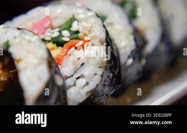Cook prepares sushi rolls with fresh ingredients in a kitchen Stock ...